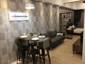 Um espaço de estar moderno com área de refeições, sofá, estante e cama.
