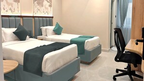 Quarto de hotel com duas camas, uma escrivaninha e aparelho de ar condicionado.