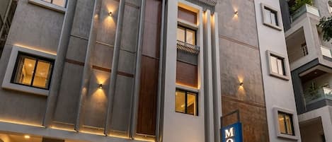Entrada de hotel com placa indicando 'Monday Hotel' e 'Restaurante'.