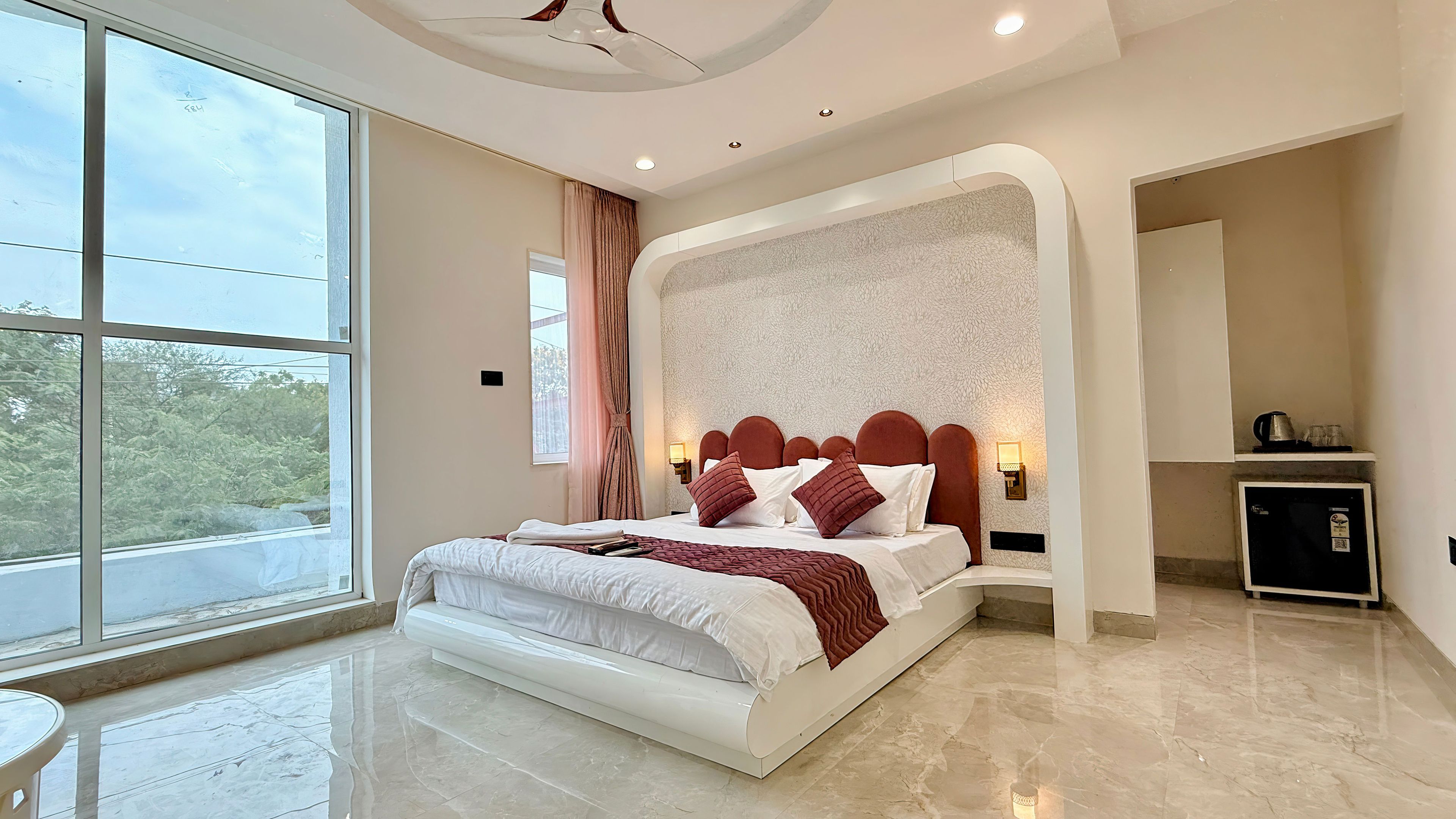 Quarto de hotel moderno com uma cama grande, uma kitchenette pequena e vista para o exterior.