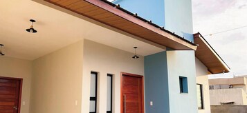Um edifício residencial com telhado plano, várias portas e uma janela visível.