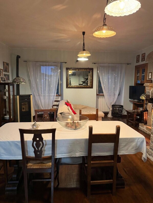 Uma sala de jantar com uma mesa posta para dois, um candelabro e um espelho grande acima da mesa.