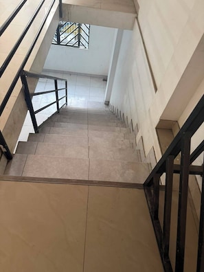 A staircase with a metal railing, leading to a higher floor.