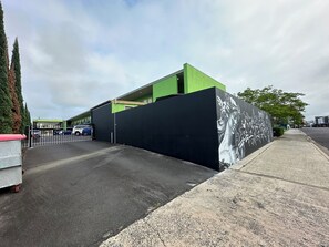 Um edifício com fachada verde e parede preta com um mural.