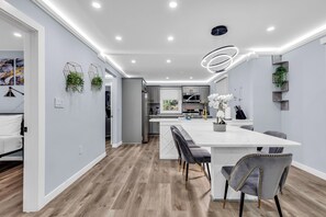 Uma cozinha moderna com uma ilha central, armários cinza e backsplash em padrão herringbone.