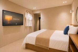 Quarto de hotel com uma cama, uma televisão na parede e um porta-robes.