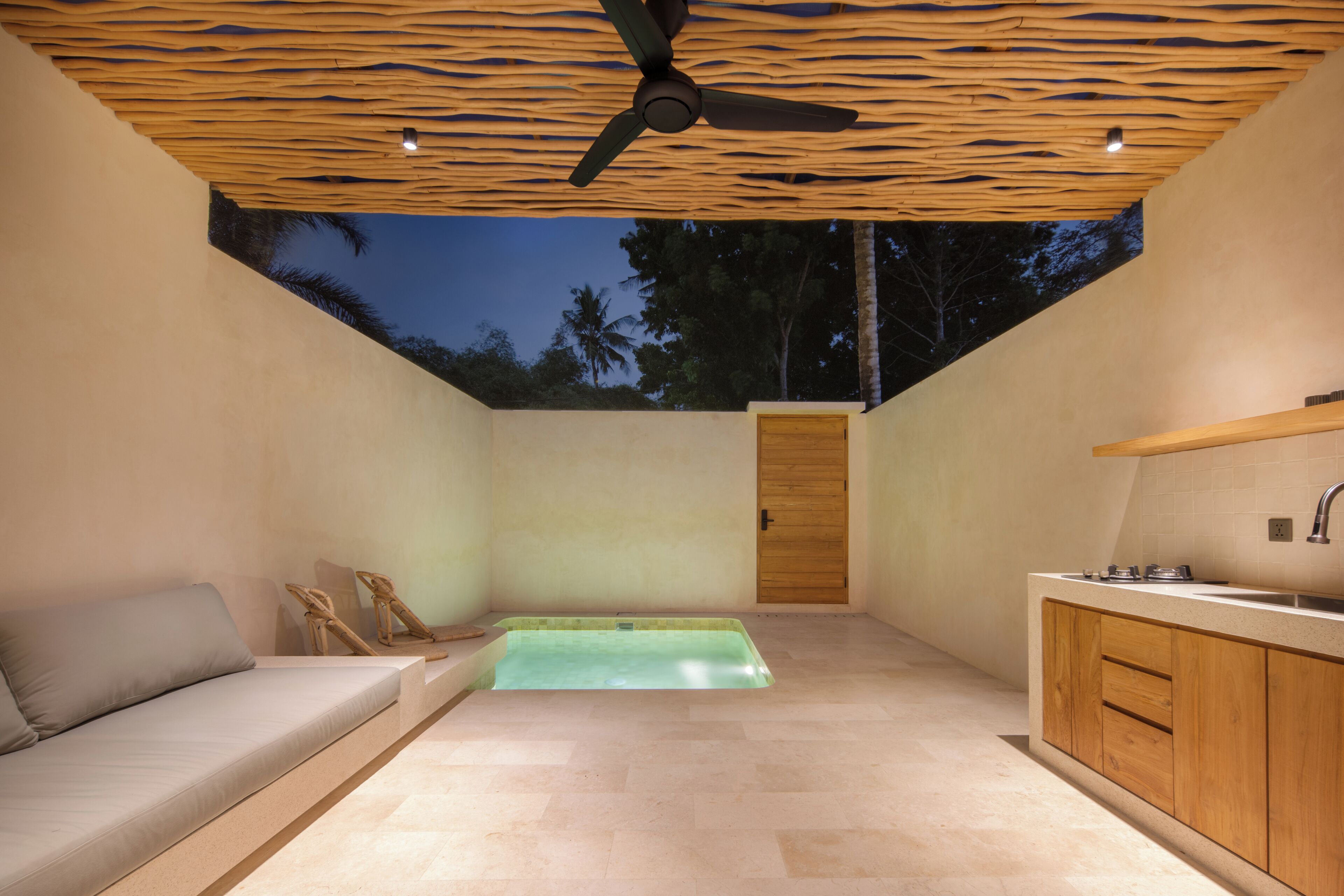 Um espaço moderno para atividades ao ar livre, com piscina, sofá e área de cozinha.