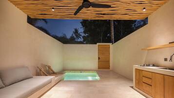 Um espaço moderno para atividades ao ar livre, com piscina, sofá e área de cozinha.