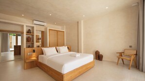 Quarto moderno com cama de madeira, nichos embutidos e um pequeno espaço de estar.