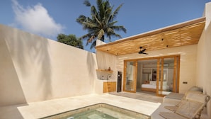 Uma área de piscina moderna com piscina transparente, espreguiçadeira e quarto com porta de correr de vidro.