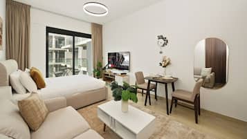 Quarto de hotel moderno com cama, sofá, mesa de jantar e televisão.