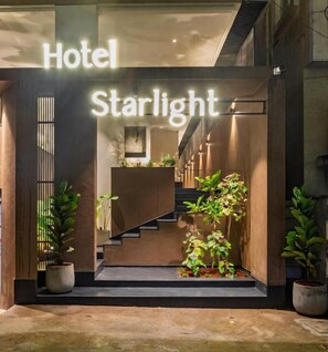Entrada de hotel com uma escadaria que leva ao interior.
