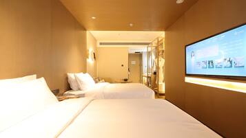 Quarto de hotel com duas camas, uma televisão exibindo um menu e teto de madeira.
