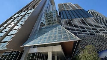Um moderno edifício alto com um design angular característico e fachada de vidro refletante.