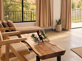 Sala de estar moderna com sofá, mesa de centro de madeira e vista para uma varanda.