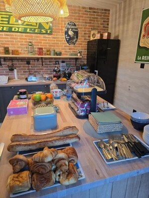 Um balcão de pequeno-almoço com pastelaria, frutas e produtos para o café da manhã.