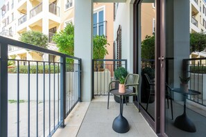 Uma varanda com mesa, cadeiras e um vaso de planta.