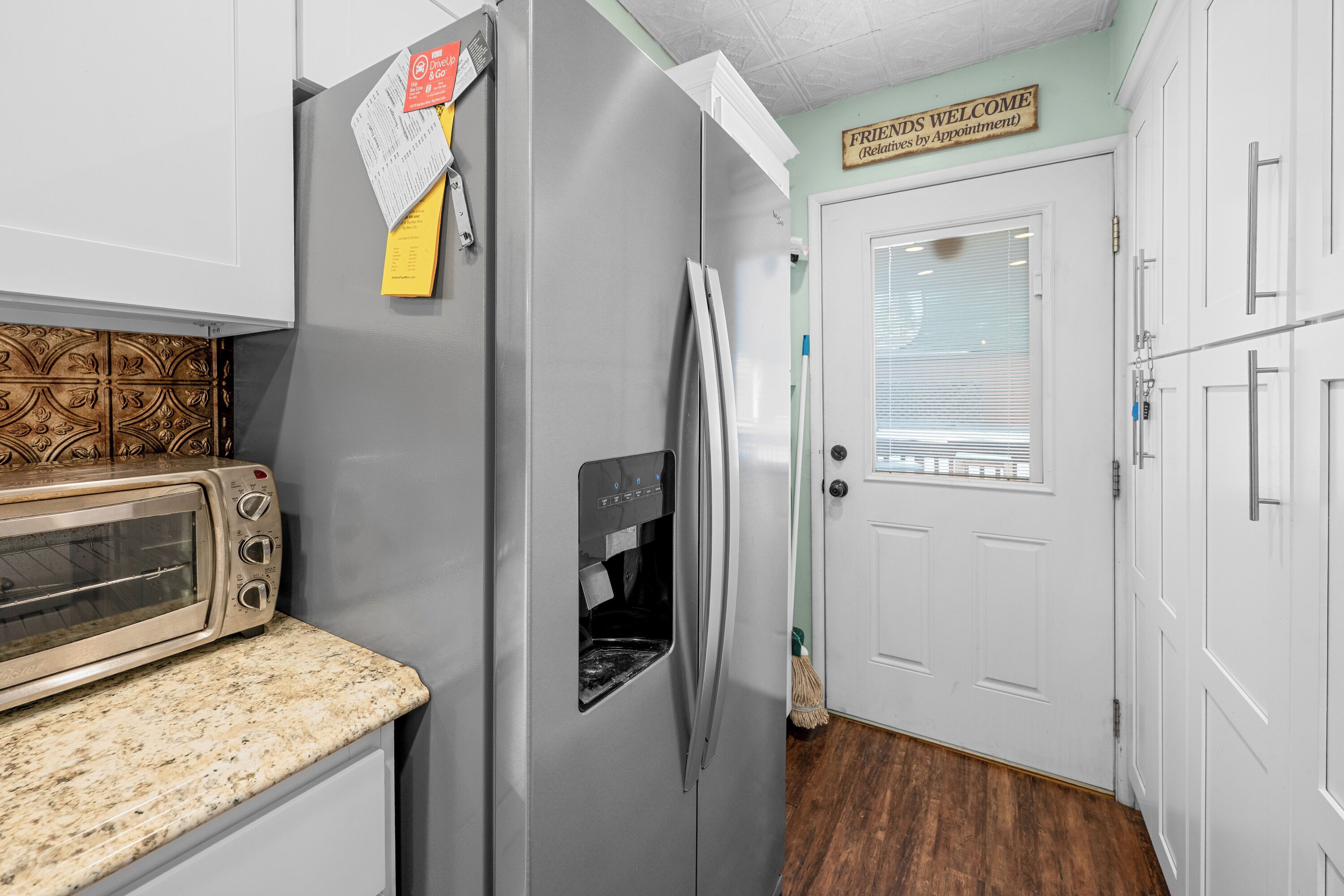 Uma cozinha com geladeira de aço inoxidável, micro-ondas e armário de madeira.