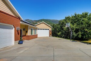 Um imóvel residencial com garagem, entrada para carros e um aro de basquete.