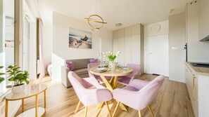 Uma área de jantar moderna com mesa redonda, cadeiras cor-de-rosa e design minimalista.