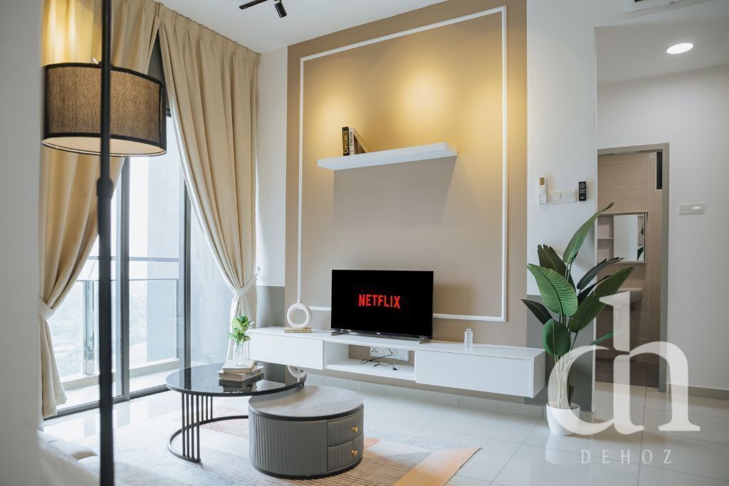 Uma sala de estar moderna com televisão de tela plana, uma mesa de centro redonda e uma janela grande com cortinas.