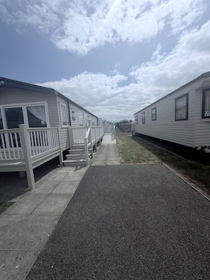 Fileira de casas móveis com um caminho de brita entre elas.