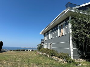 Uma casa de dois andares com vista para o mar.