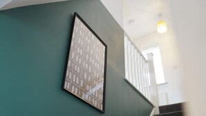 Uma escada com corrimão e um quadro fixado na parede.