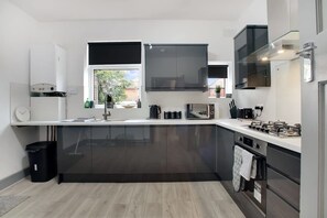 Uma cozinha moderna com uma ilha grande, eletrodomésticos embutidos e vista para o exterior.