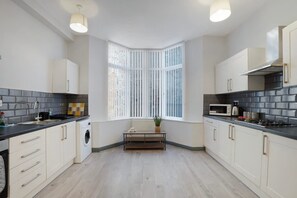Uma cozinha moderna com janela saliente, eletrodomésticos embutidos e uma ilha central.