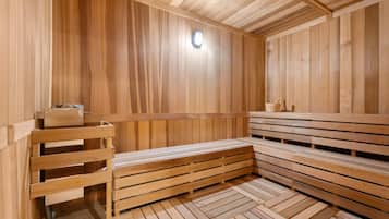 Uma sauna com bancos de madeira e um banco com toalha e bolsa.
