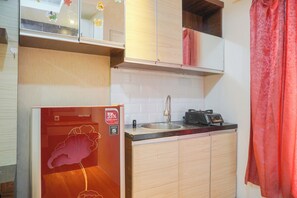 Cozinha compacta com geladeira, pia e fogão.