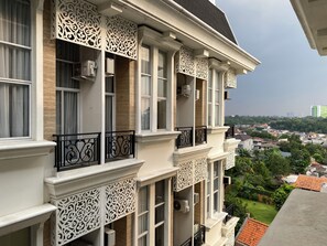 Um edifício com várias andares, varandas ornamentadas e grandes janelas.