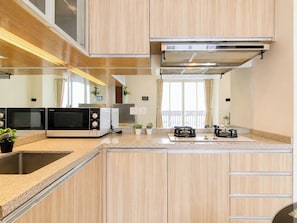 Cozinha moderna com eletrodomésticos embutidos, bancada de granito e vista para o exterior.