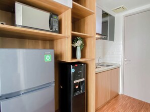 Cozinha equipada com frigorífico, micro-ondas e dispensador de água.