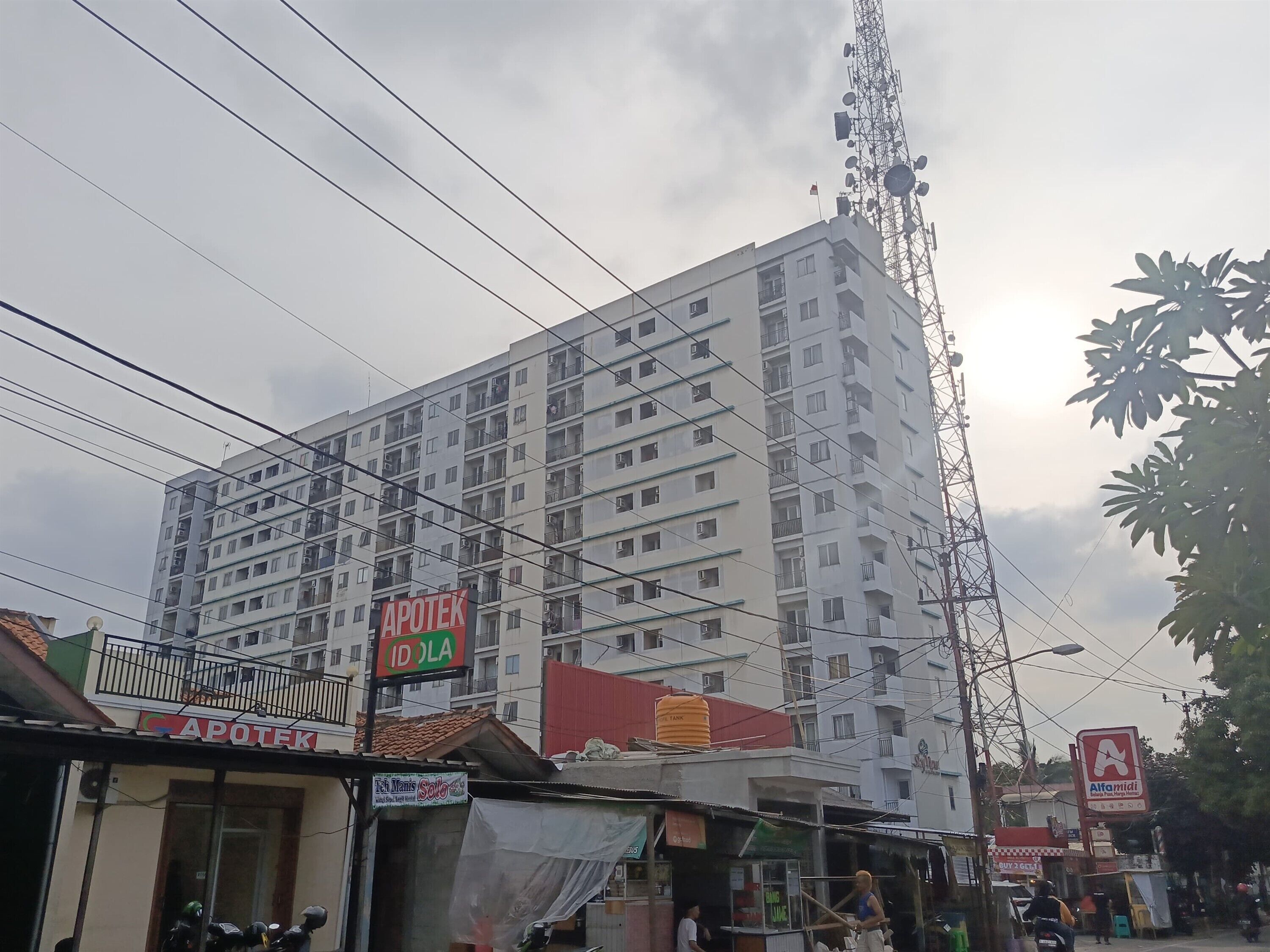 Um edifício com várias andares, varandas e uma antena grande.