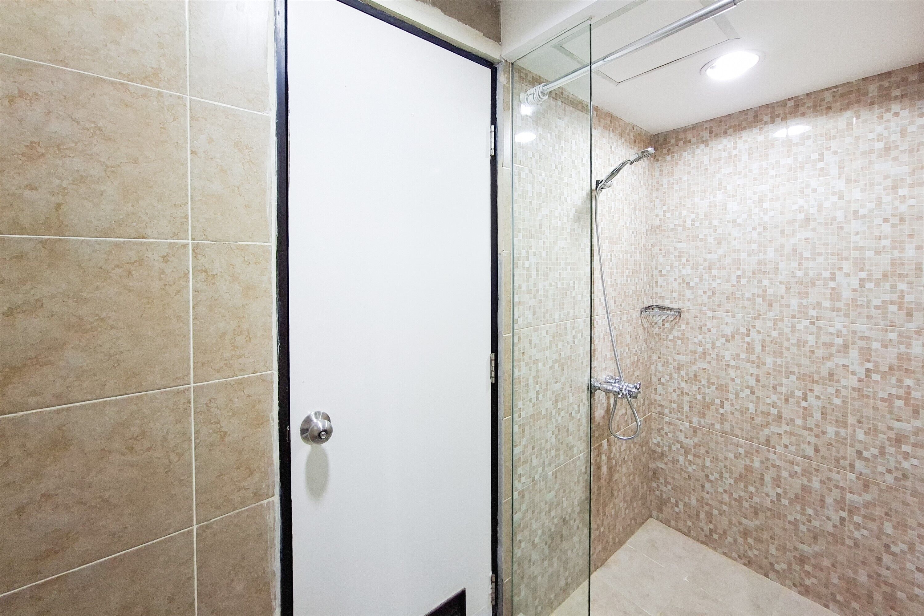 Box de chuveiro envidraçado com parede revestida e porta.