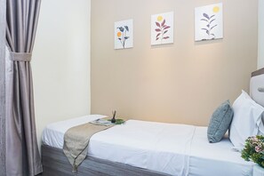 Quarto com cama, mesa de cabeceira, obra de arte na parede e cortina.