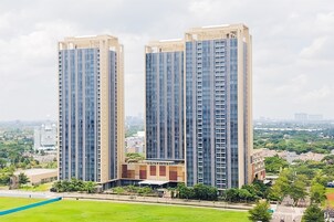 Dois edifícios altos com um campo desportivo ao primeiro plano.