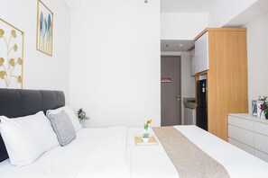 Quarto moderno com cama, mesa de cabeceira e vista para a cozinha.