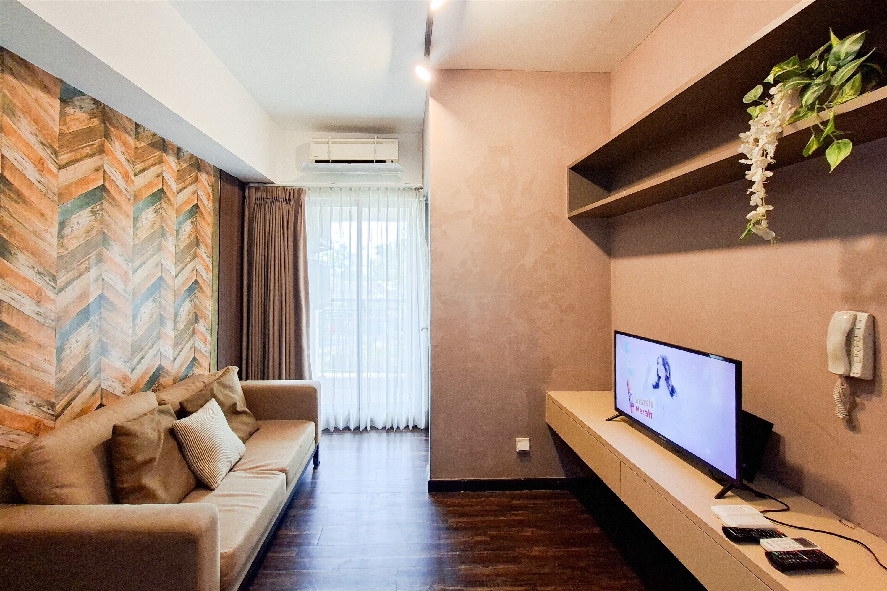 Uma sala de estar moderna com um sofá, uma televisão de tela plana e um painel decorativo.