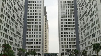 Um edifício alto com fachada em estilo grade, vários andares e um pátio central com árvores.