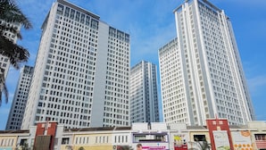 Um edifício moderno de arranha-céu com uma grade de janelas e telhado plano.