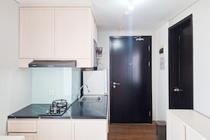 Cozinha compacta com fogão a gás, pia e armários.