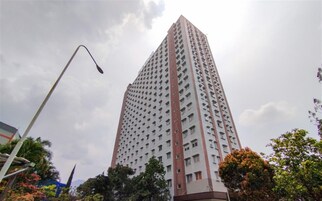 Um edifício alto, com vários andares, fachada uniforme e várias janelas.