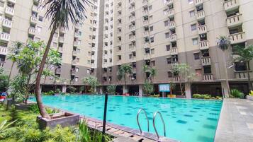 Um edifício residencial com várias varandas e uma piscina.