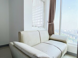 Quarto com uma grande janela, um sofá e vista para uma ponte.