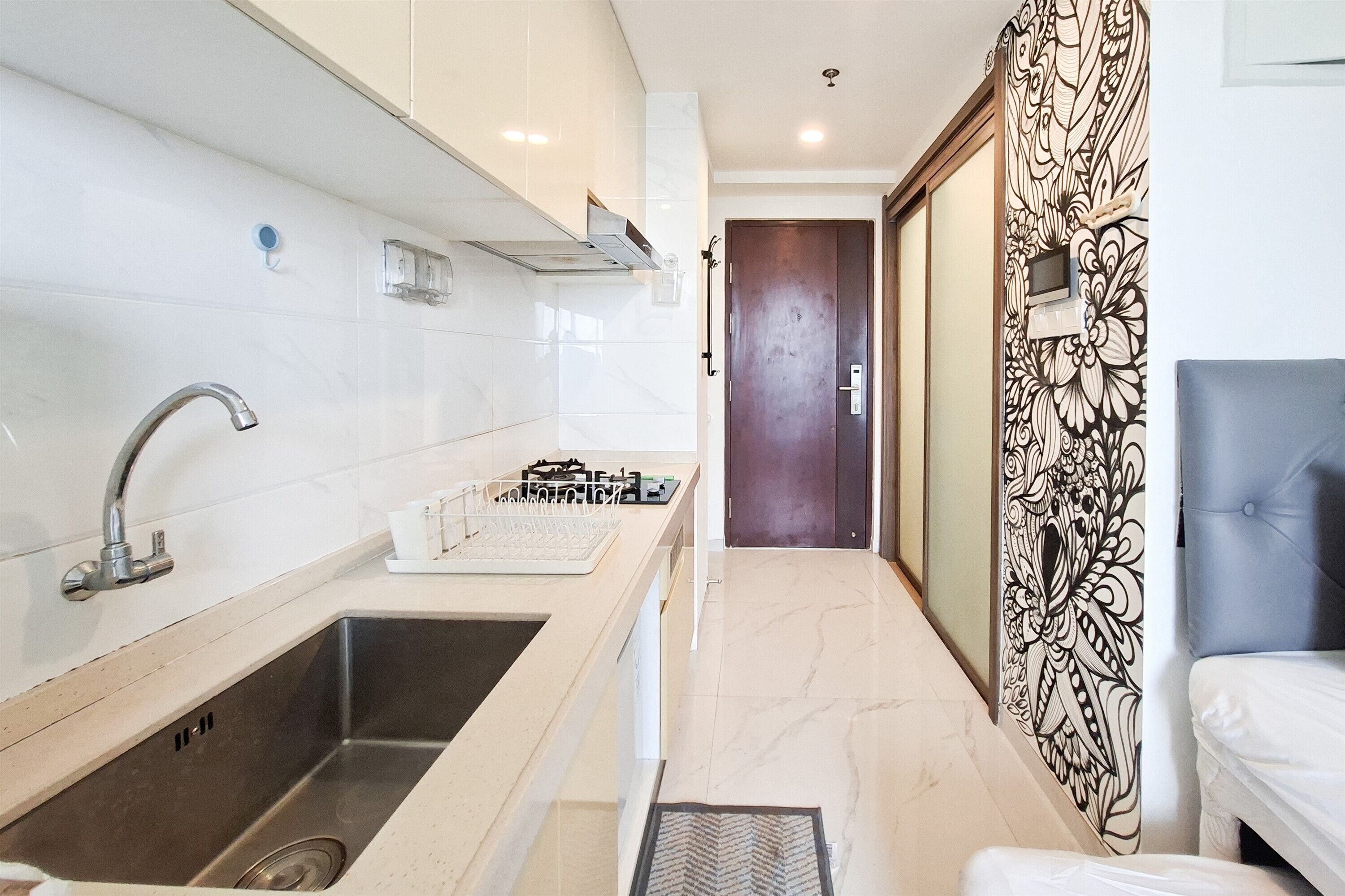 Cozinha moderna com pia, fogão e painel decorativo.