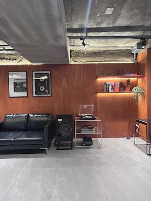 Um interior moderno com sofá de couro, um alto-falante preto e um balcão de recepção de madeira.