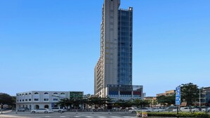 Um edifício alto e moderno com fachada de vidro e sinalização em língua estrangeira.